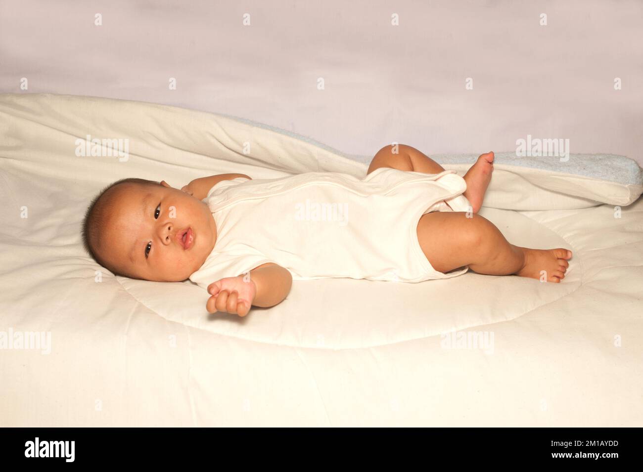 Newborn Asian baby girl lying and happiness on a bed Stock Photo - Alamy
