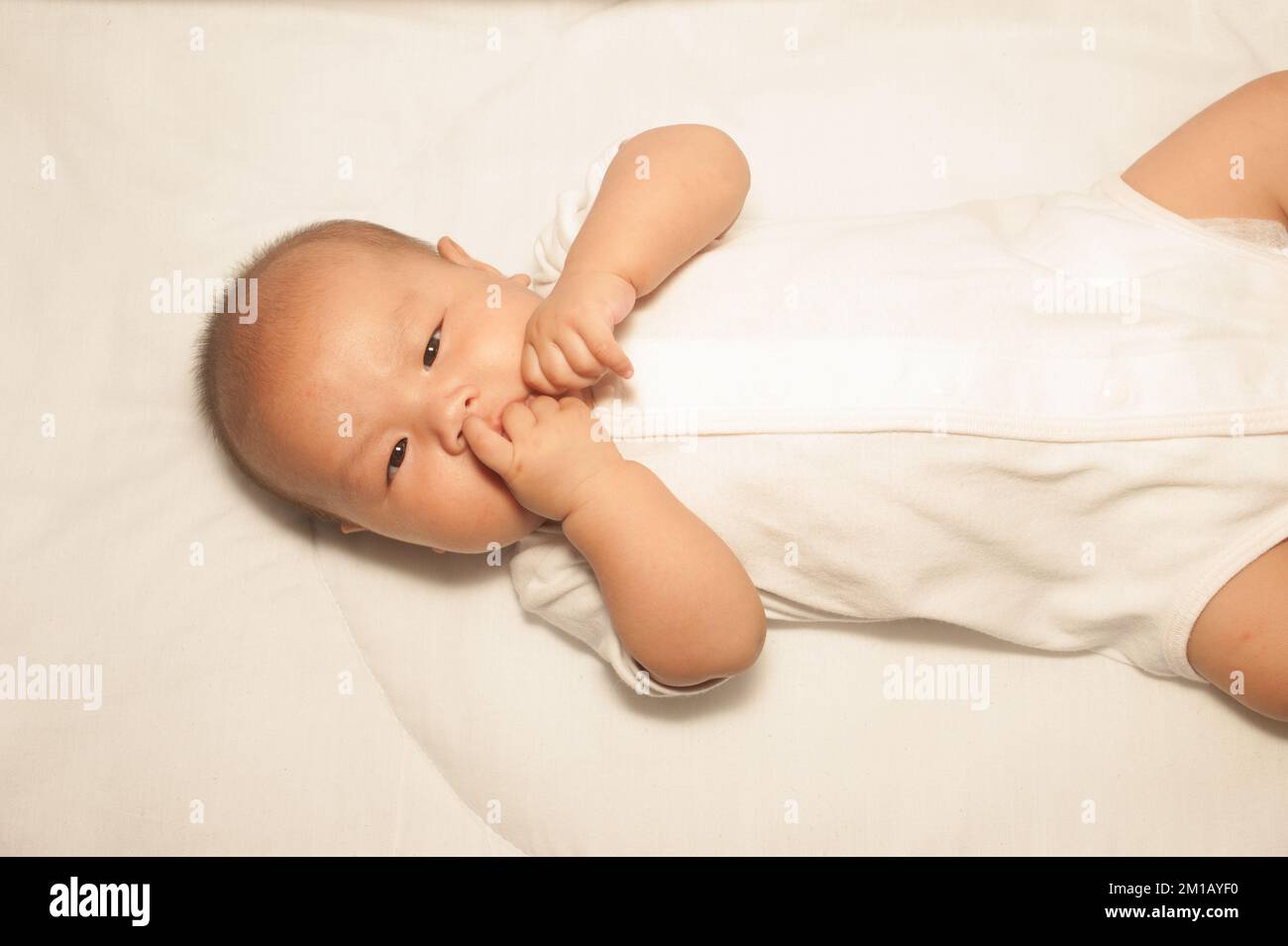 Newborn Asian baby girl lying and happiness on a bed Stock Photo - Alamy