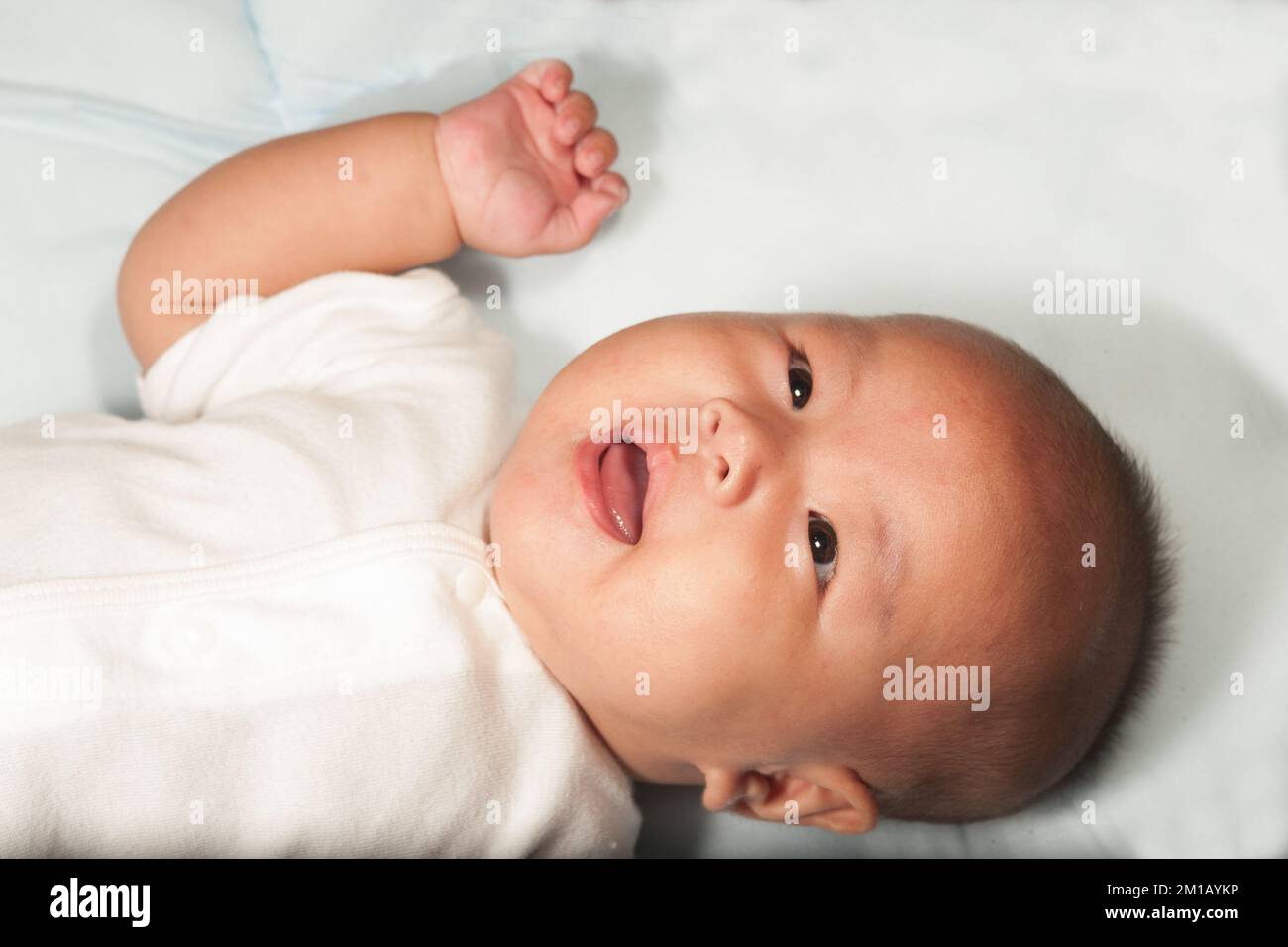 Newborn Asian baby girl lying and happiness on a bed Stock Photo - Alamy