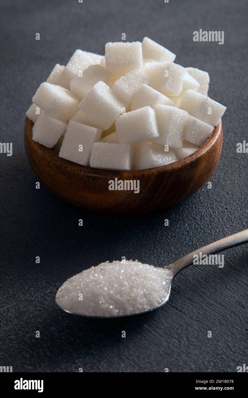 Cube sugar and granulated sugar on dark background Stock Photo - Alamy