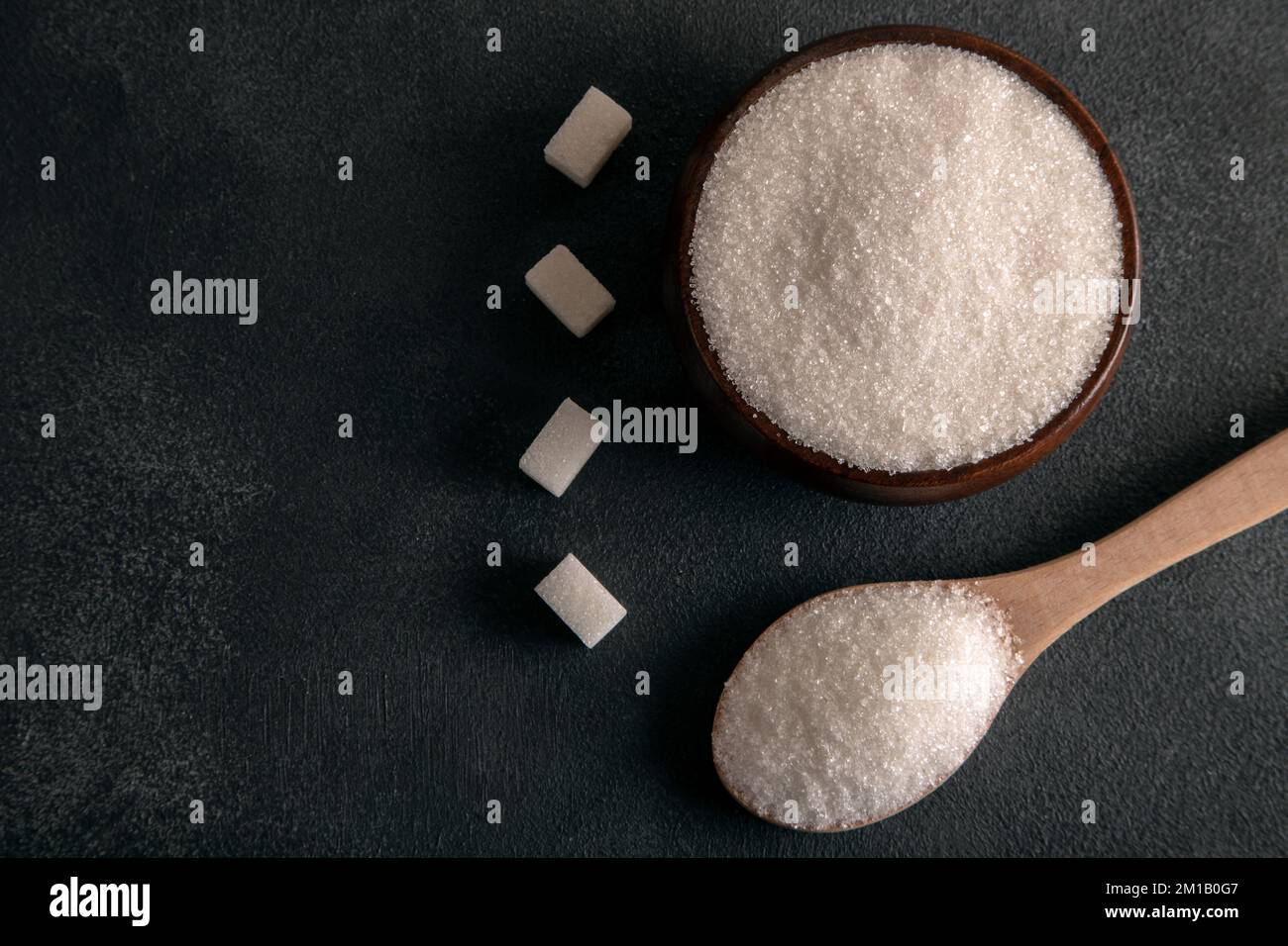 Cube sugar and granulated sugar on dark background Stock Photo - Alamy
