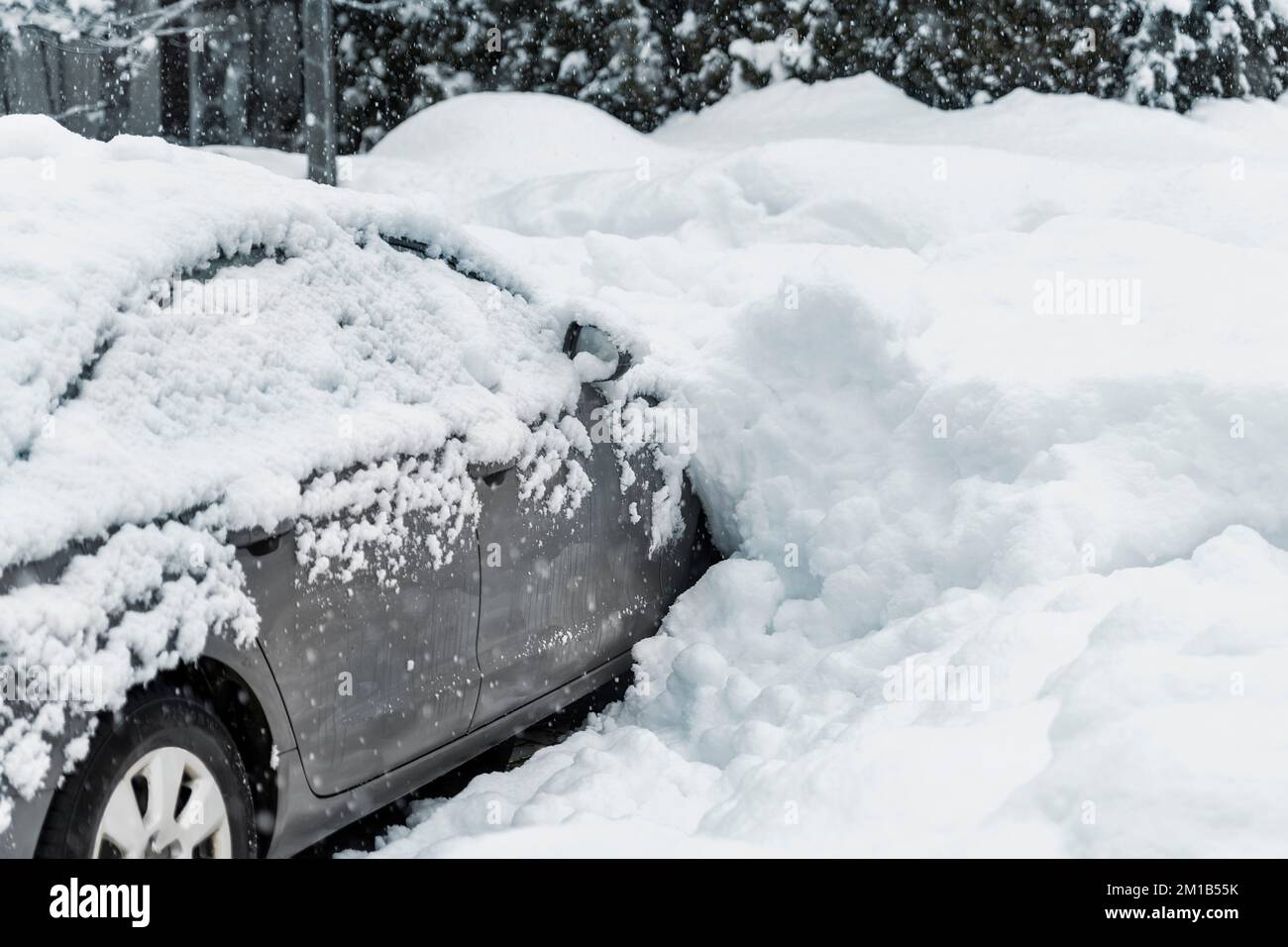 City street driveway parking lot spot with small car covered snow stuck ...