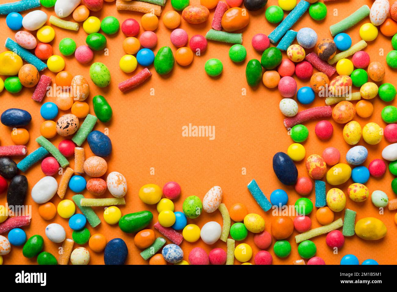 Mixed collection of colorful candy, on colored background. Flat lay ...