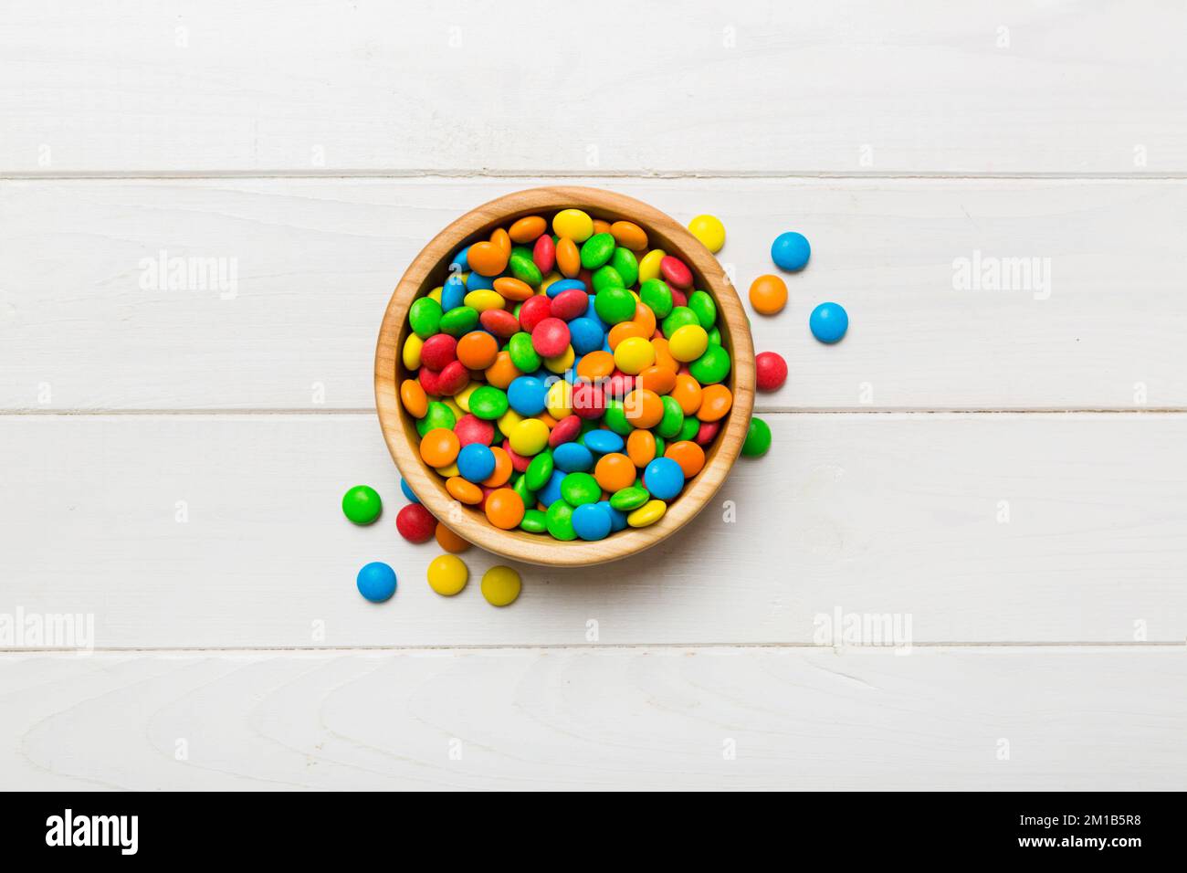 Multicolored candies in a bowl on a colored background. birthday and ...