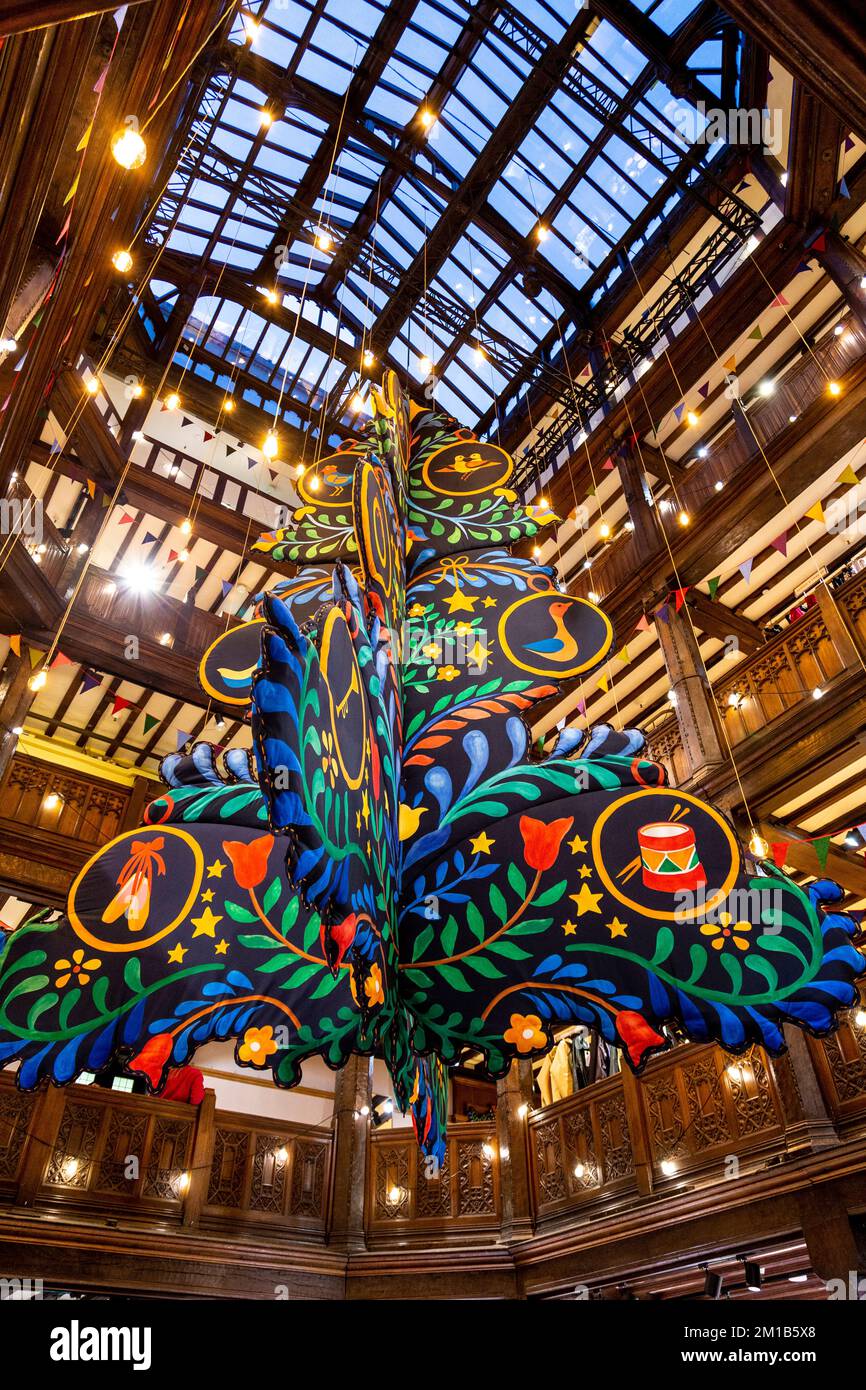 A large Christmas tree suspended from the ceiling at Liberty London, UK ...