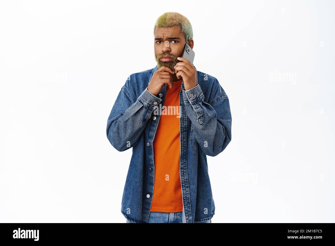 African american guy talks on mobile phone and thinks, order smth via ...
