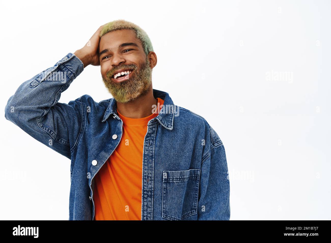Close up of handsome, carefree Black man, touches his yellow hairstyle ...