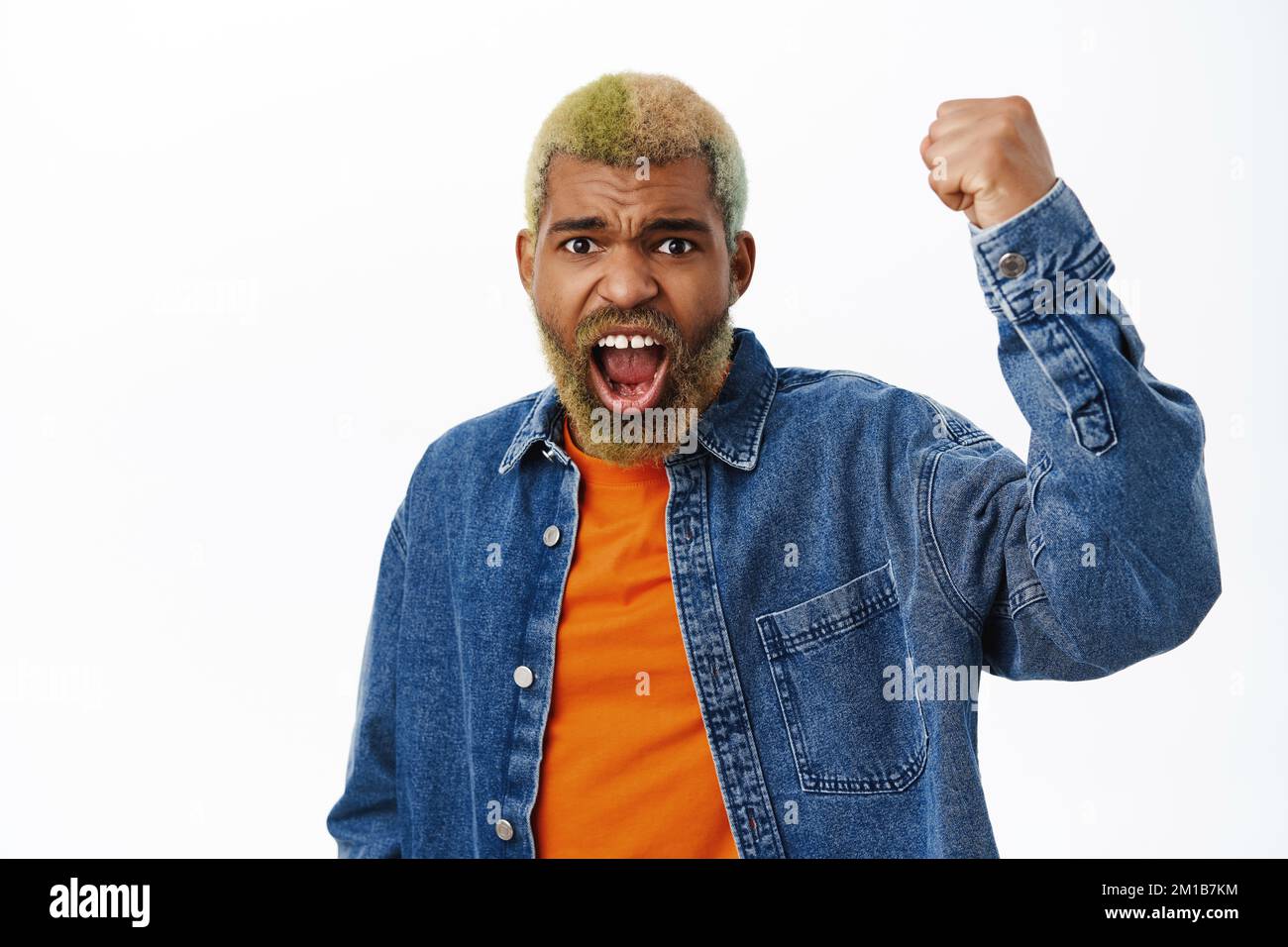 Portrait of enthusiastic man raising fists up, chanting, cheering and ...