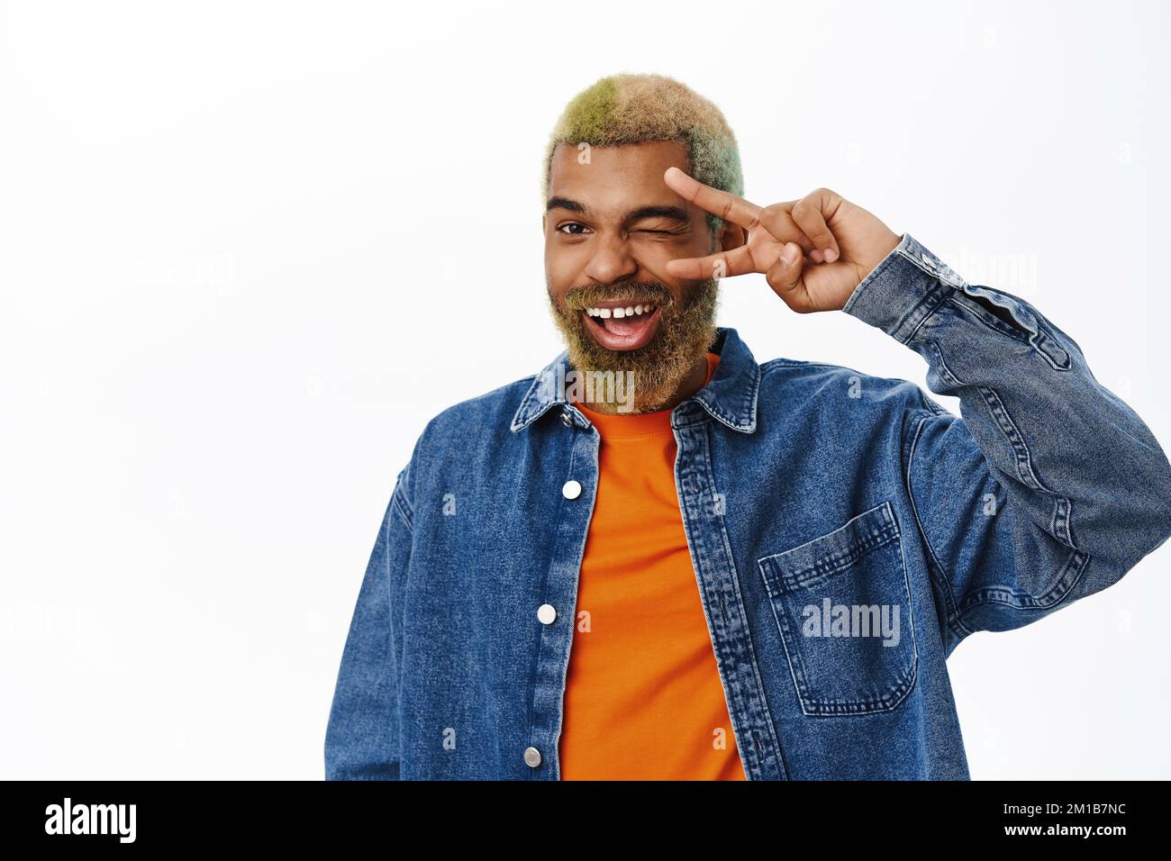 Positive african american hipster guy shows peace sign, winks and ...