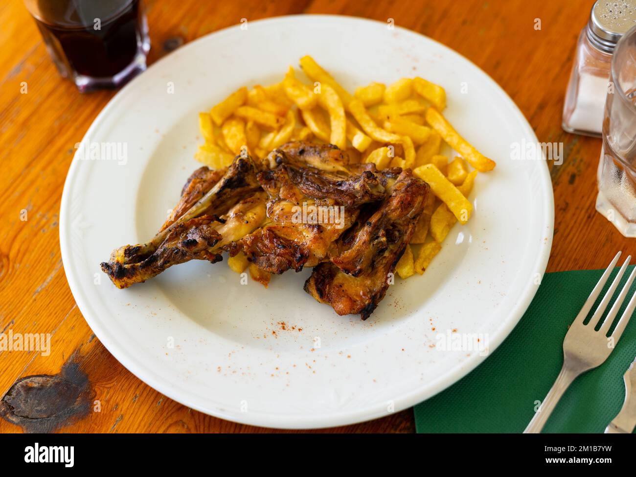 Baked rabbit leg with side dish of french fries Stock Photo - Alamy