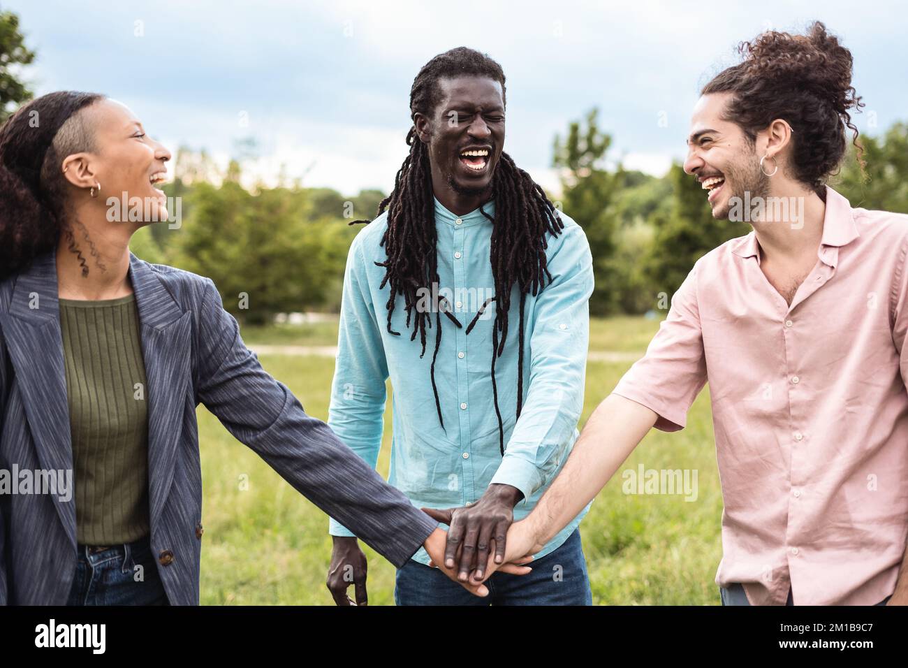 Happy multiracial friends having fun together hanging out in the park ...