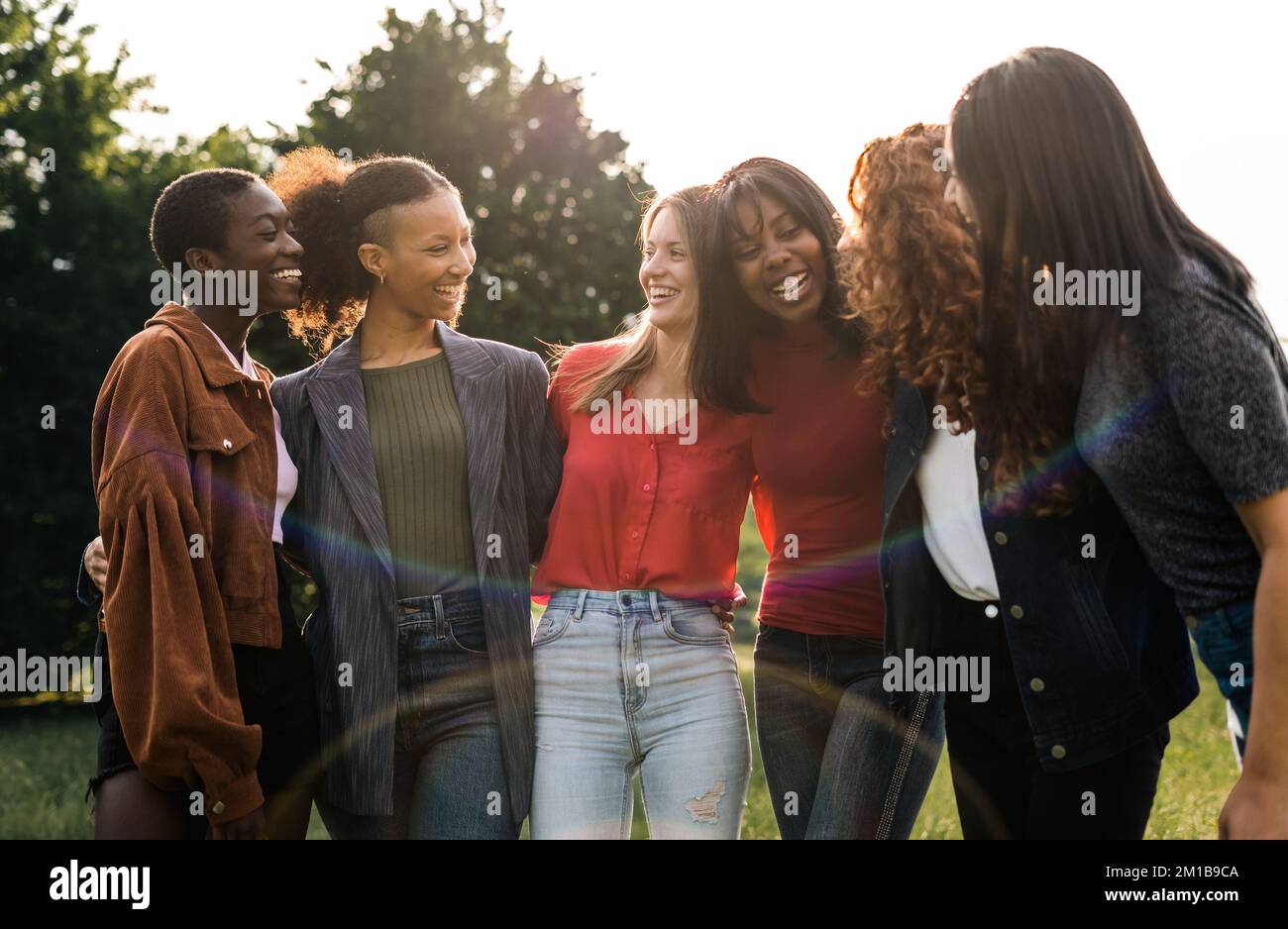 Multiracial friends embracing together on park outdoor - Portrait of ...