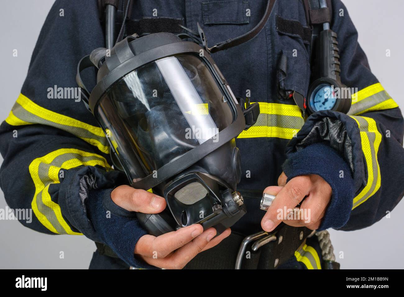 Full protective breathing air mask in hand of unrecognized firefighter ...