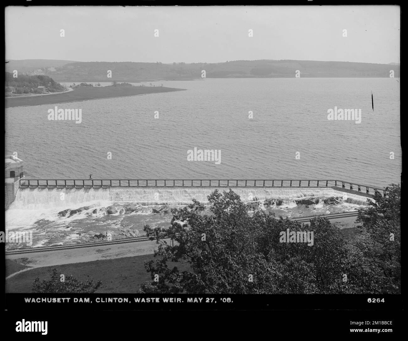 Wachusett Dam, Waste Weir, water flowing; man carrying camera on tripod ...