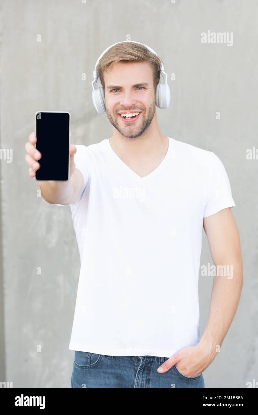 happy man presenting music app, copy space. man presenting music app ...