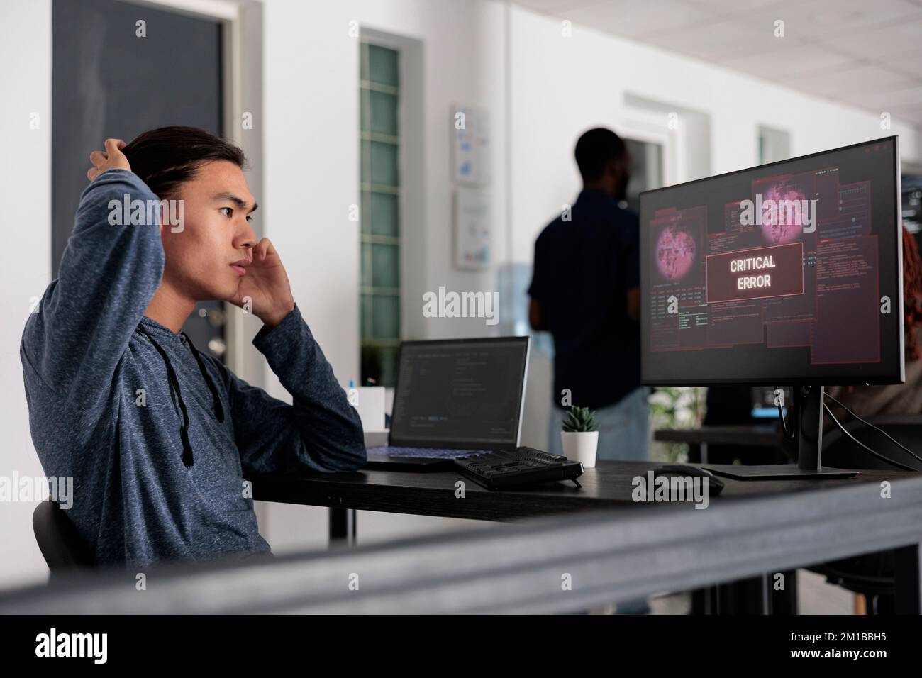 Stressed Asian Web Developer Having Security Breach Alert On Computer Screen Trying To Solve