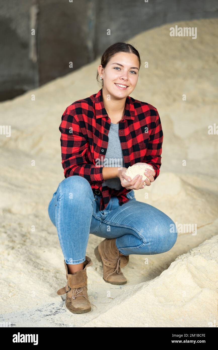 Positive woman agronomist squatting at bunch of corn flour Stock Photo ...