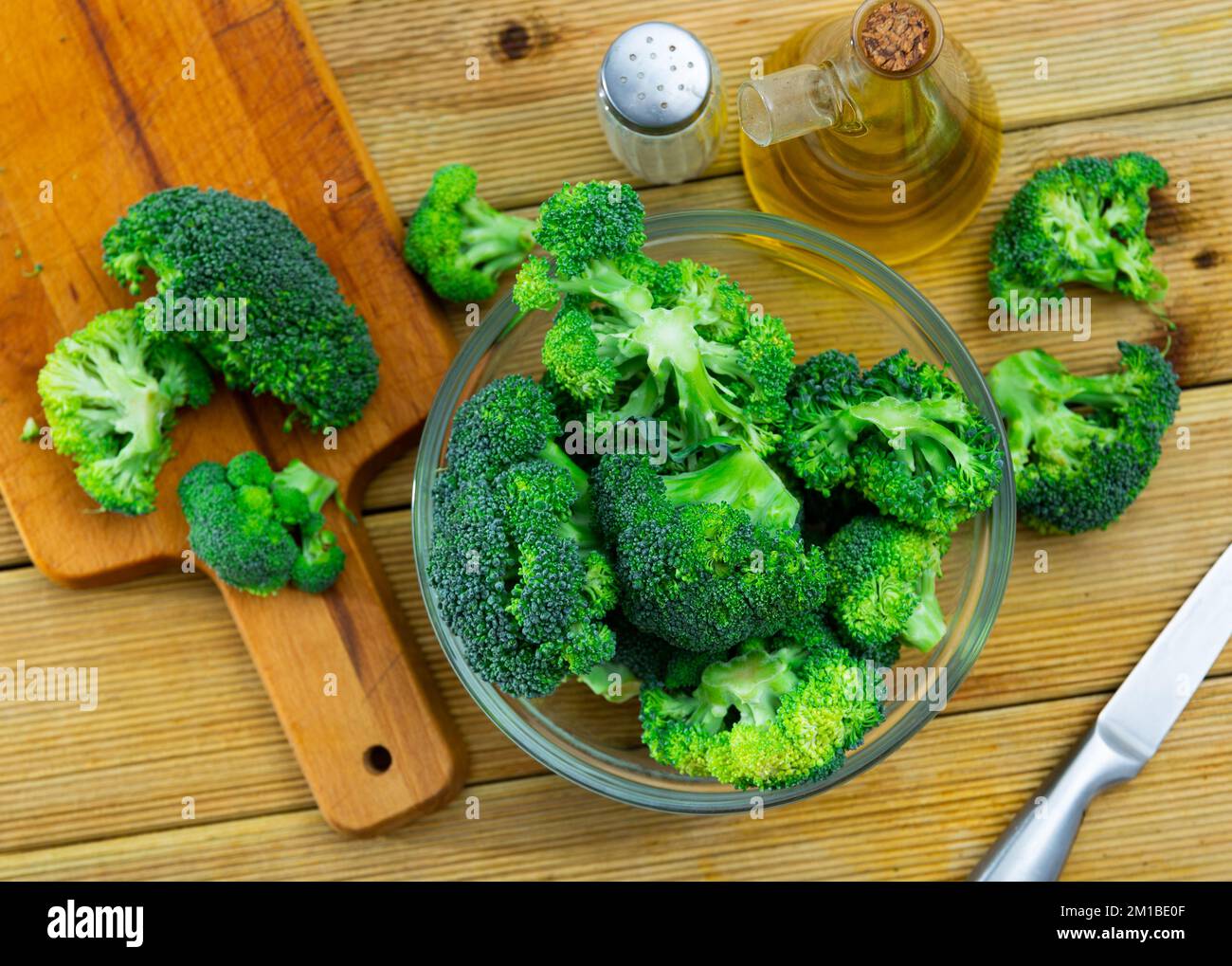 Glass bowl of fresh raw broccoli inflorescences with oil and spices ...