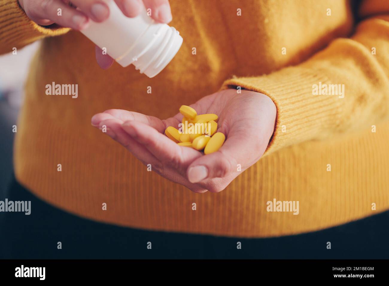 Woman taking many pills out of the bottle. Concept of drug abuse ...