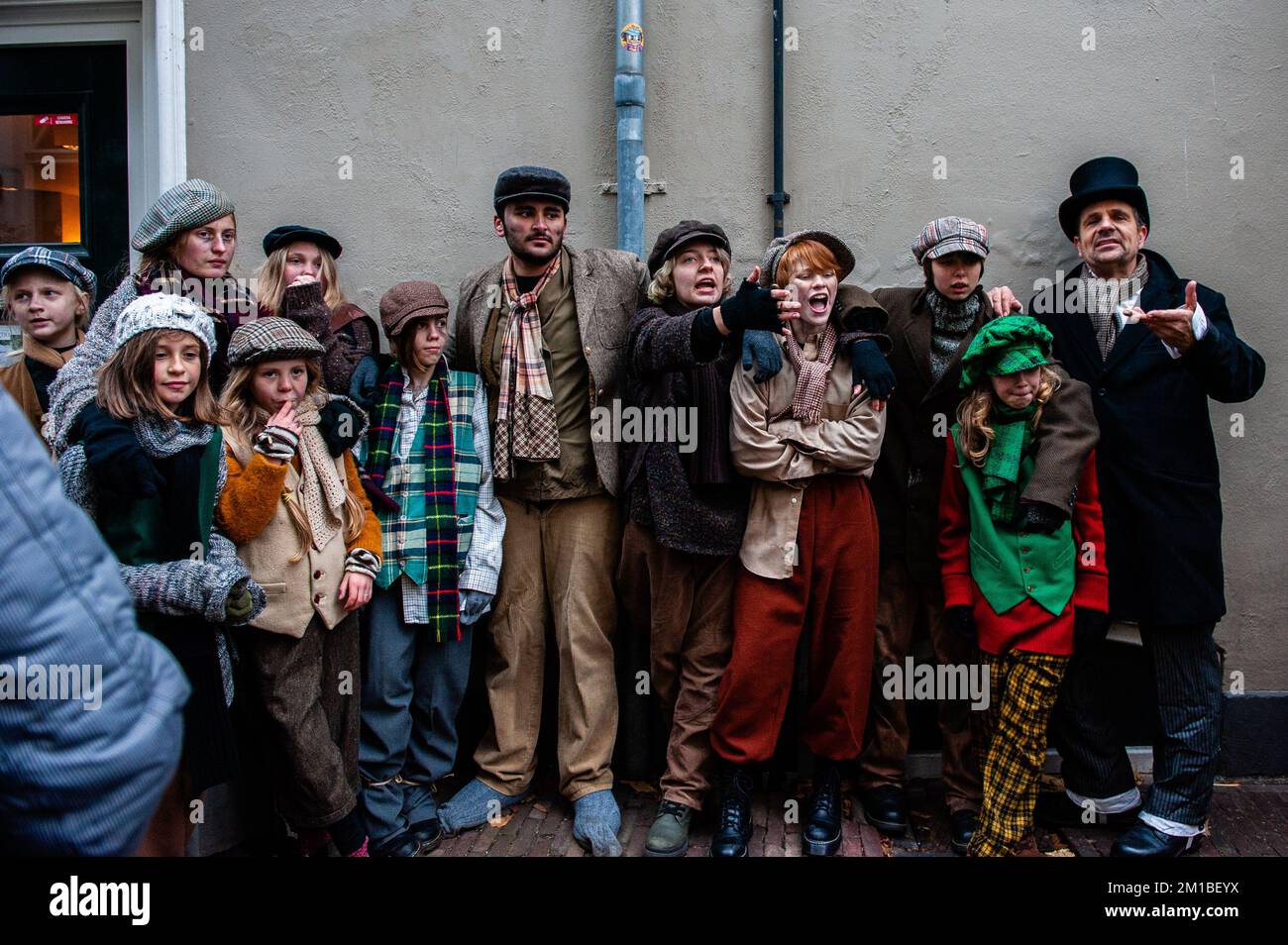 A group of children seen performing like orphans from the Victorian era ...