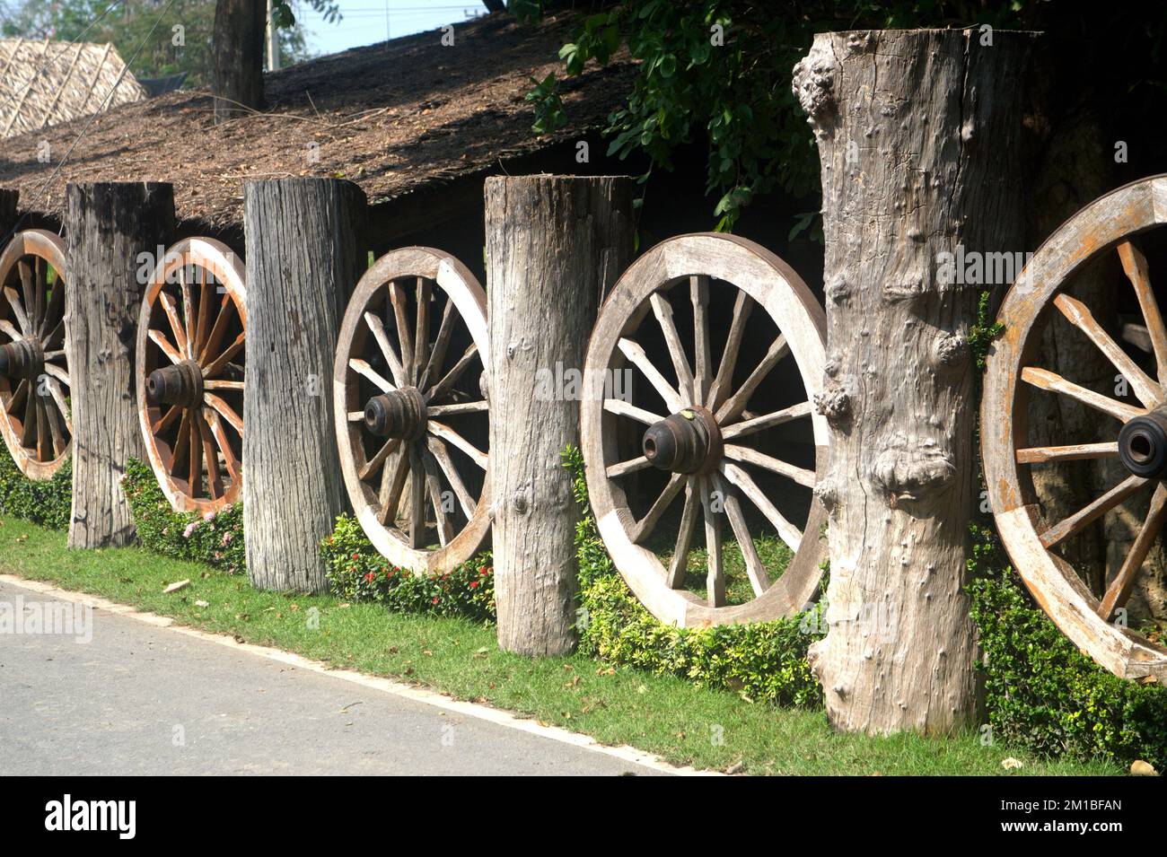 An old wheel of a traditional cart leaning on a wooden fence Stock ...