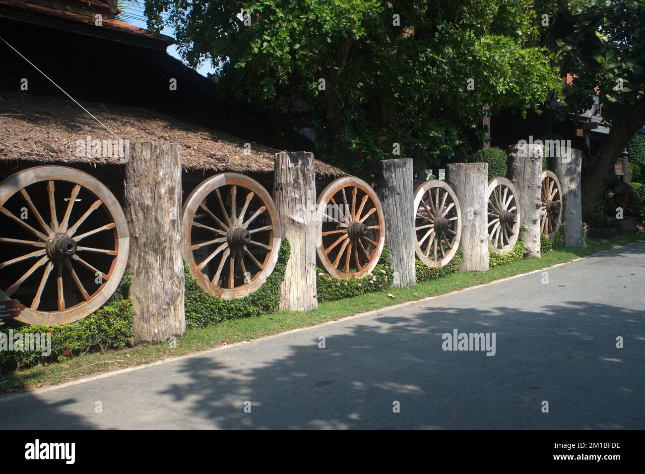An old wheel of a traditional cart leaning on a wooden fence Stock ...