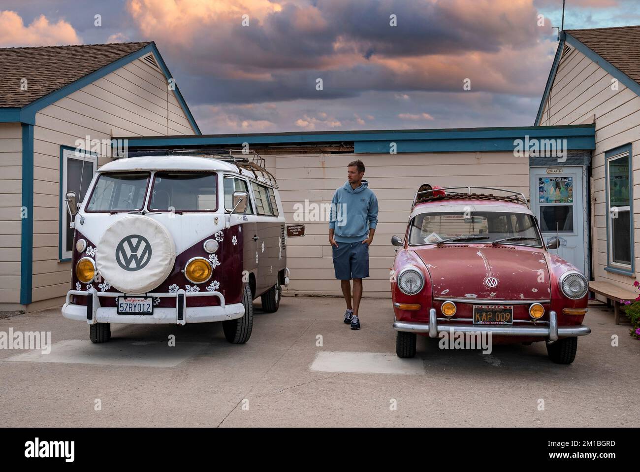 Young man standing by vintage classic VW Camper Van parked on Seafront ...