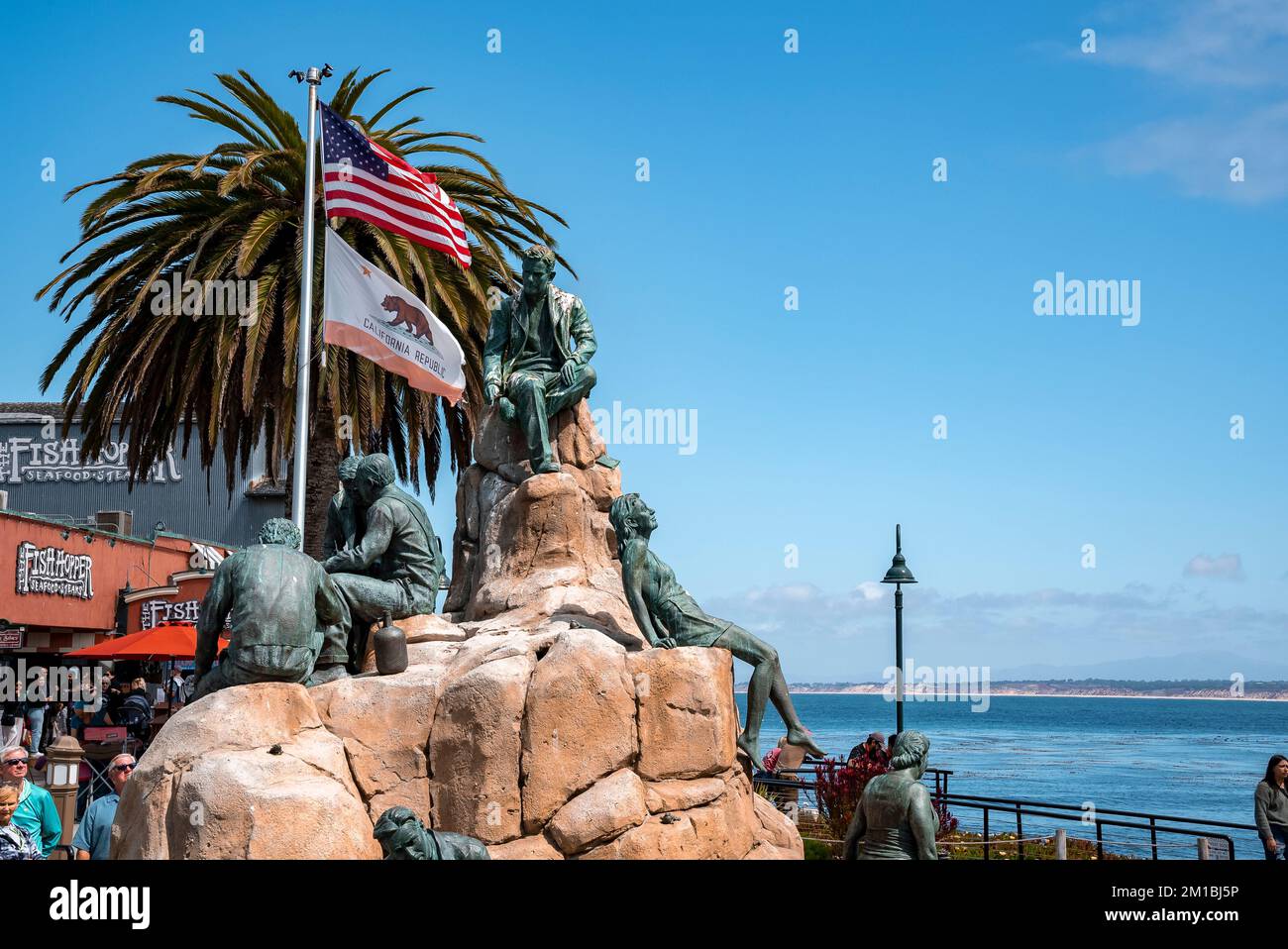 Cannery Row Monument with flags of America and California at coastline ...