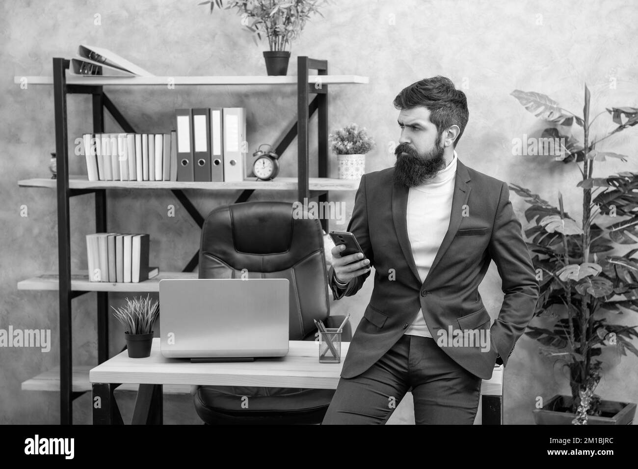 Simple way to connect. Serious man using smartphone at work. Smartphone ...