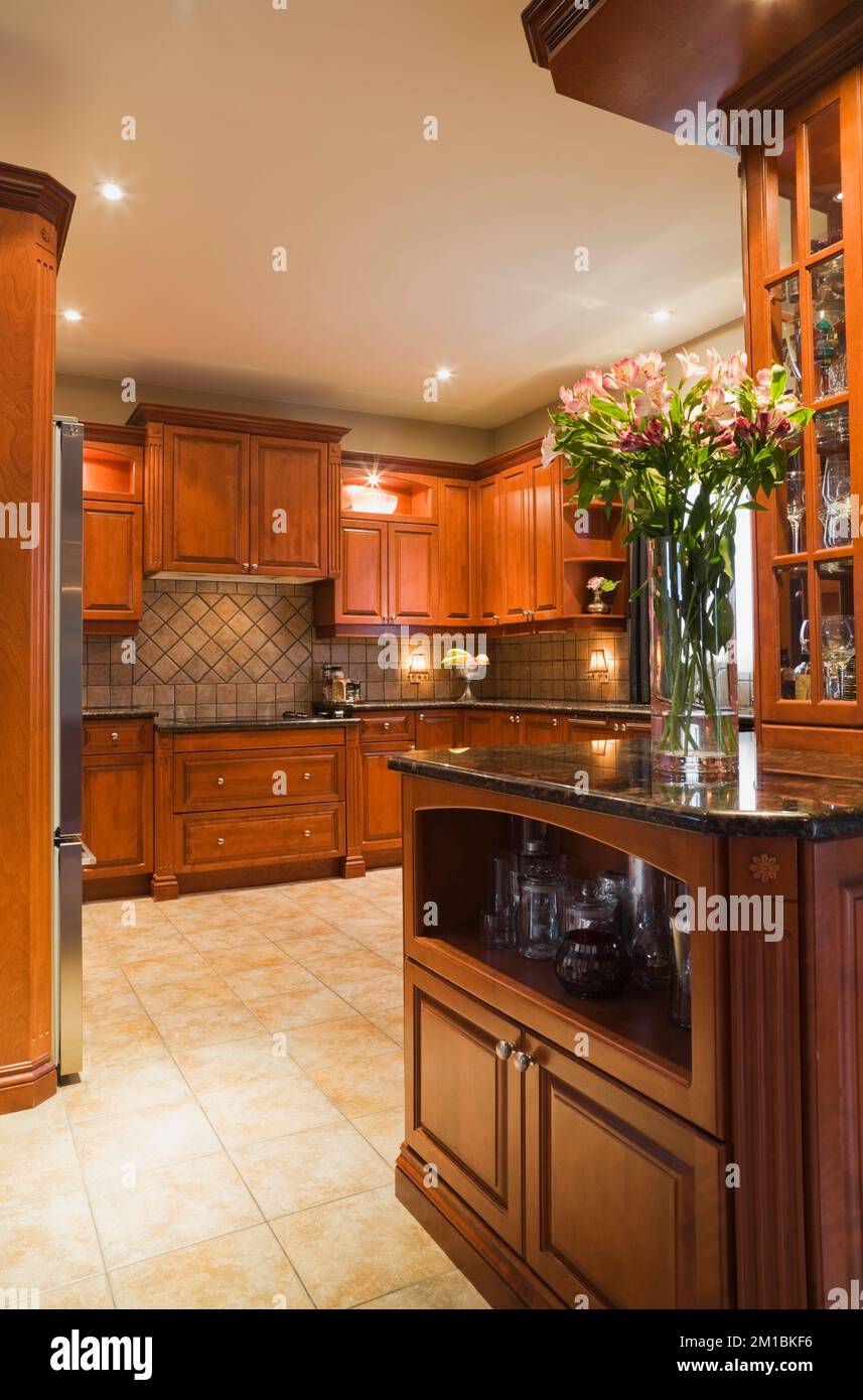 Cognac coloured wooden cabinets and dark granite countertops in ...