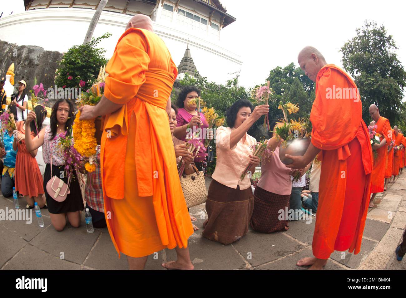 Group of monks receiving flower offering from people in Tak Bat Dok Mai ...