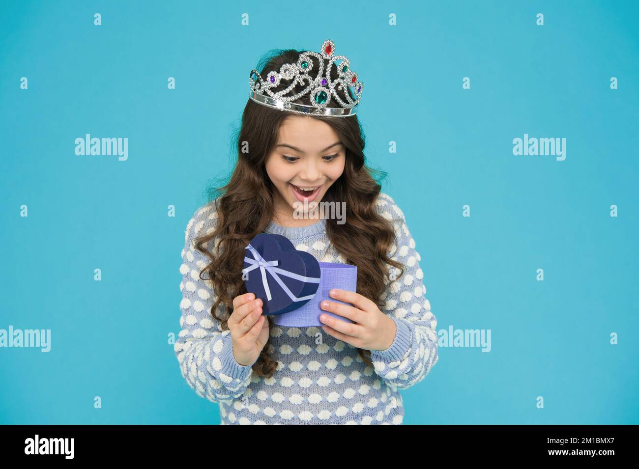 Happy little girl in crown opening birthday present box. greeting child ...