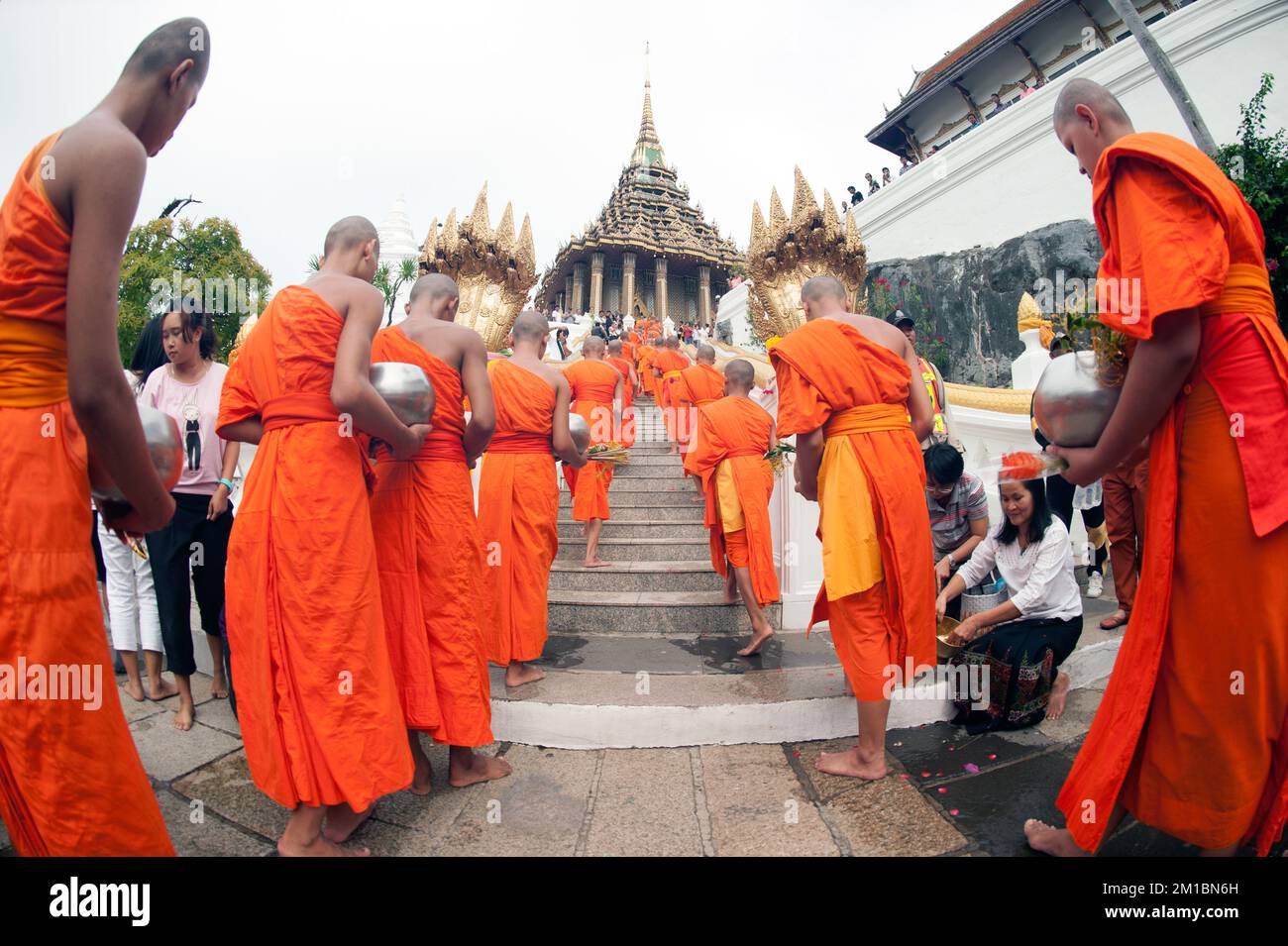 Row of Monks walking to Pagoda in Tak Bat Dok Mai Festival (give ...