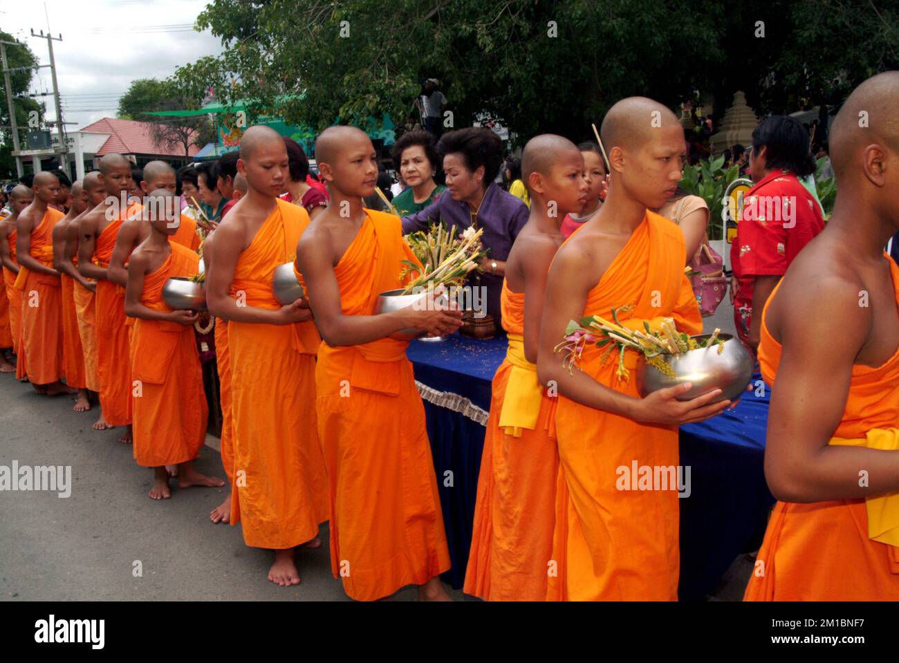 Row of Monks walking to Pagoda in Tak Bat Dok Mai Festival (give ...