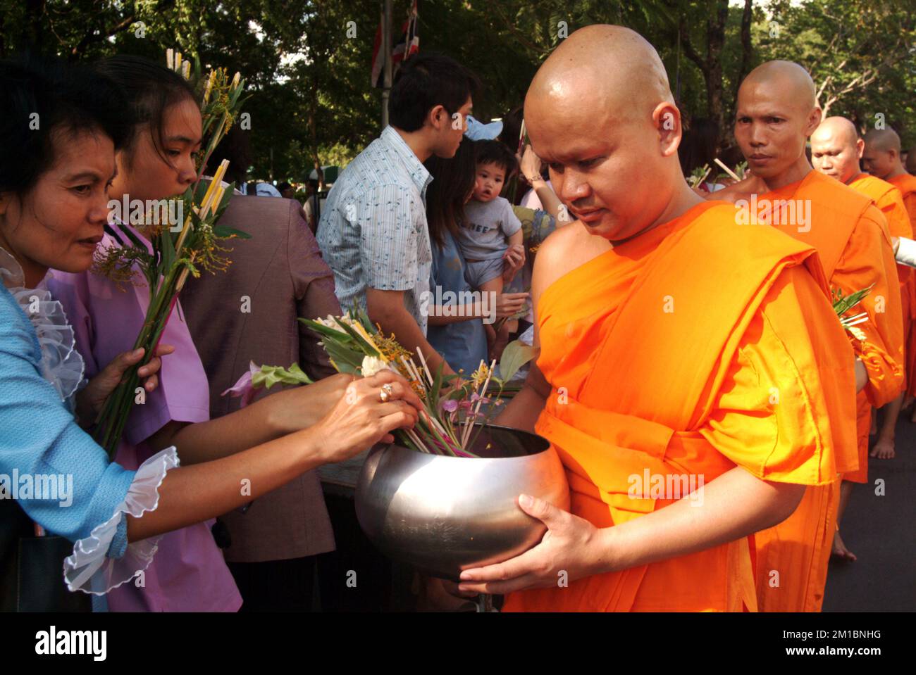 Row of Monks walking to Pagoda in Tak Bat Dok Mai Festival (give ...