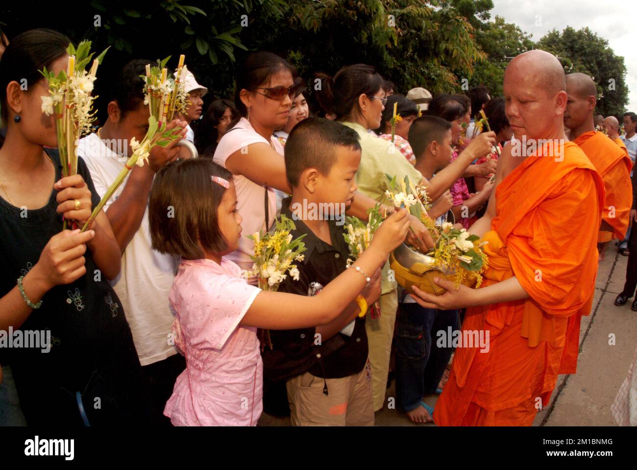 Row of Monks walking to Pagoda in Tak Bat Dok Mai Festival (give ...