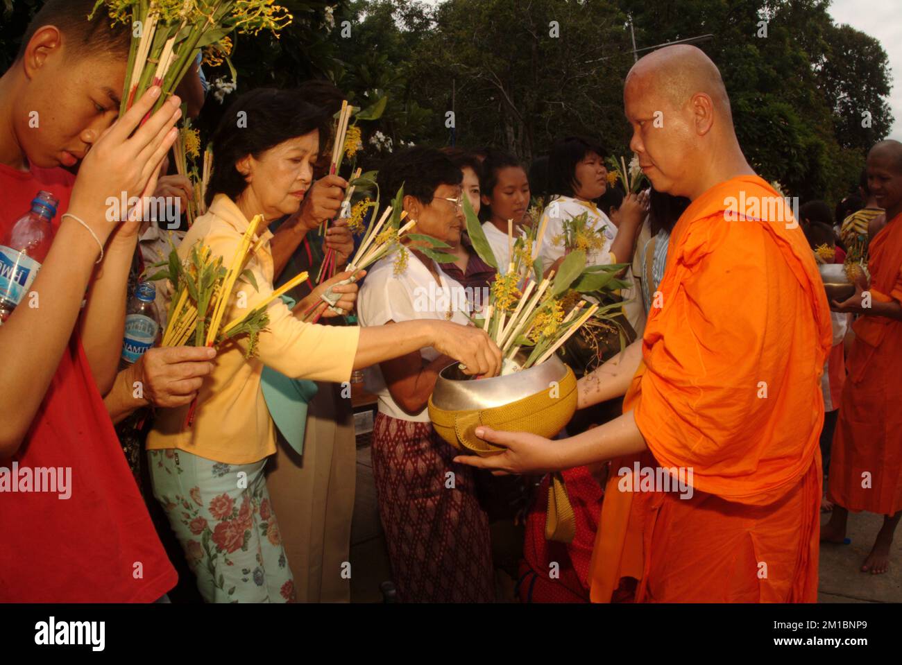 Row of Monks walking to Pagoda in Tak Bat Dok Mai Festival (give ...