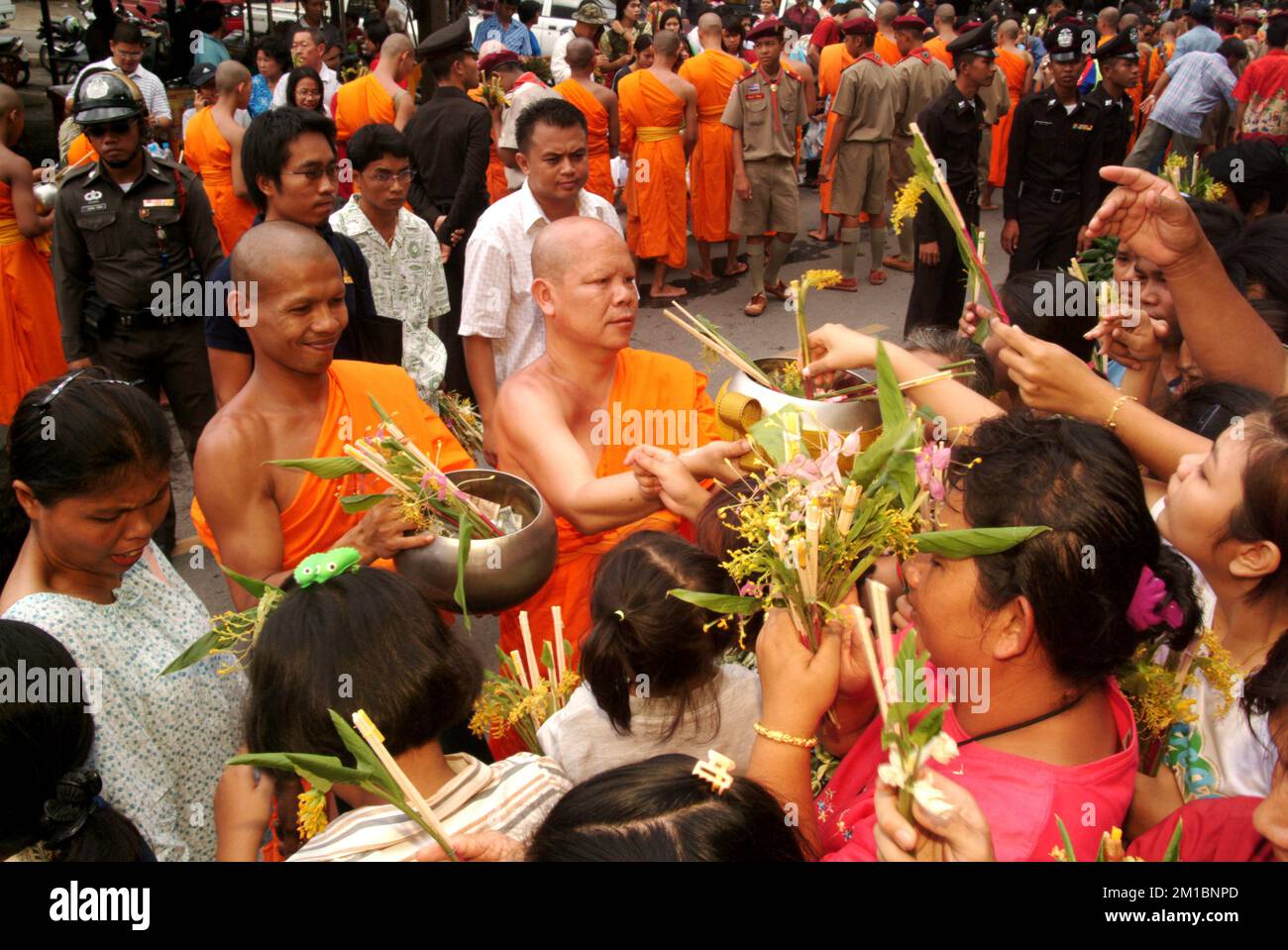 Row of Monks walking to Pagoda in Tak Bat Dok Mai Festival (give ...