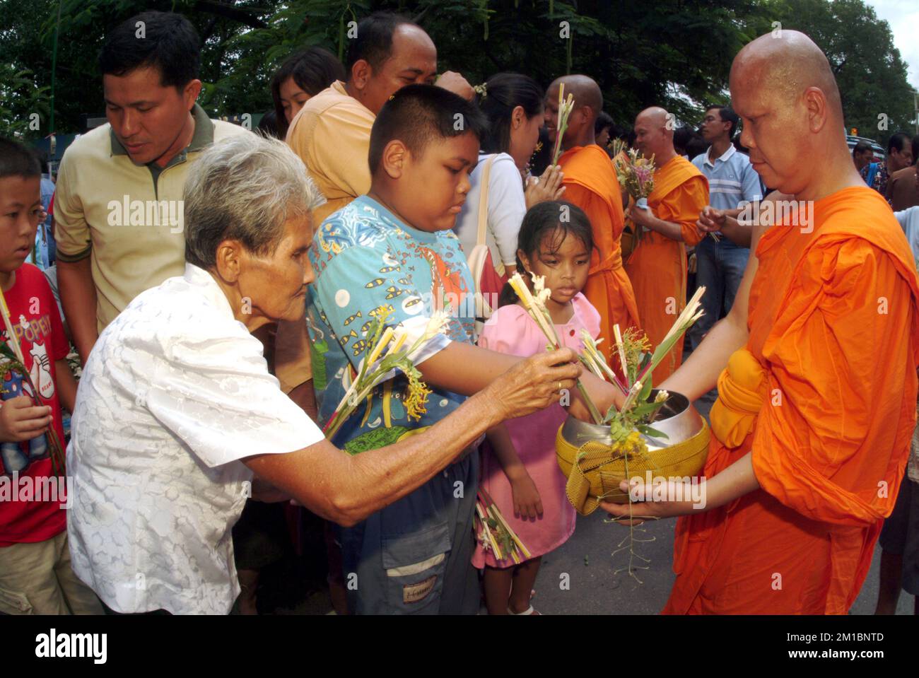 Row of Monks walking to Pagoda in Tak Bat Dok Mai Festival (give ...