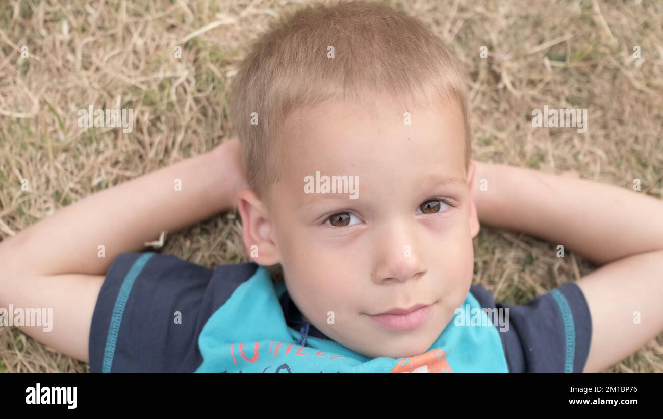 Little Happy Serious and Thoughtful Child Boy Laying on Yellow Lawn Dry ...
