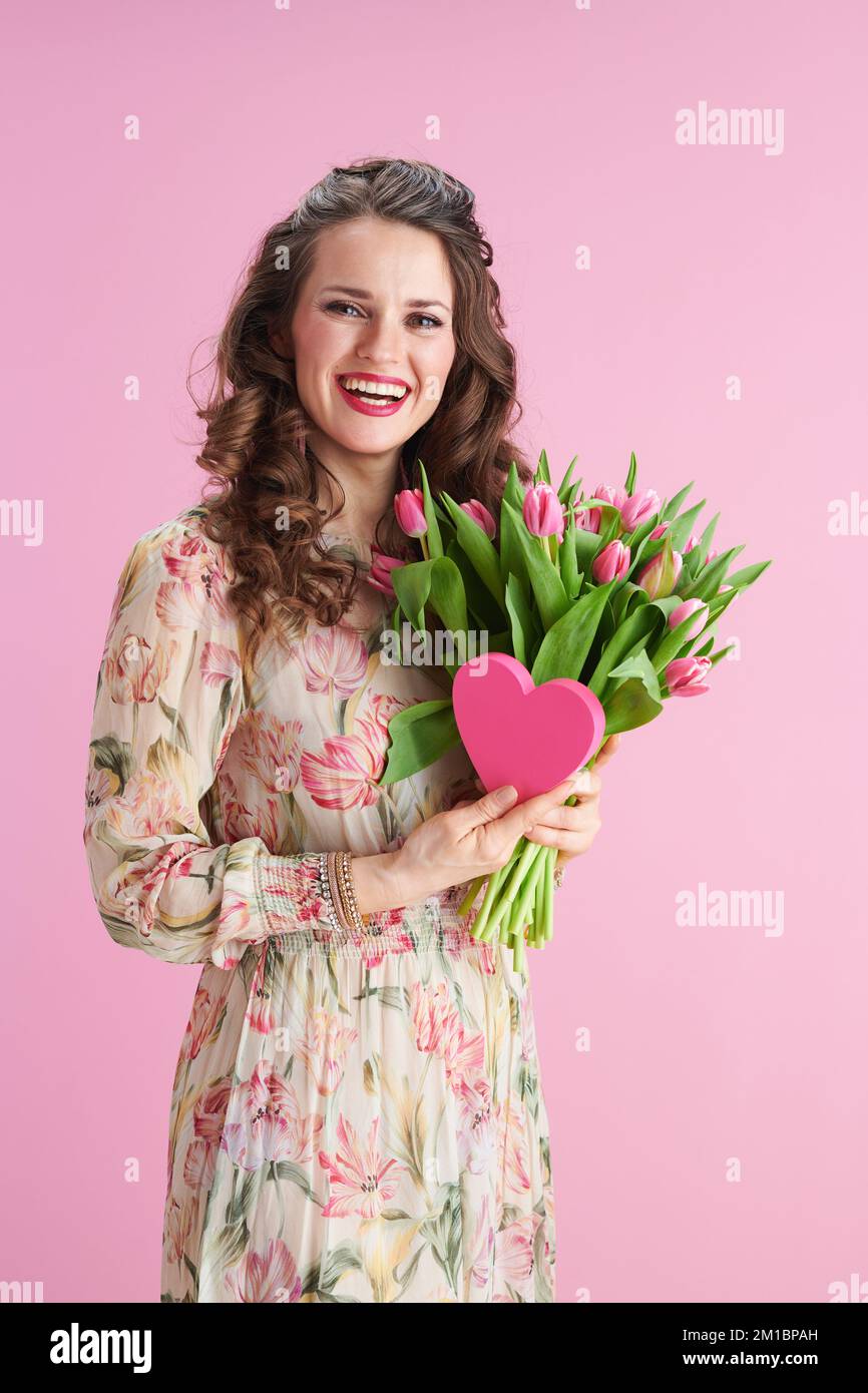 happy stylish female with long wavy brunette hair with tulips bouquet ...