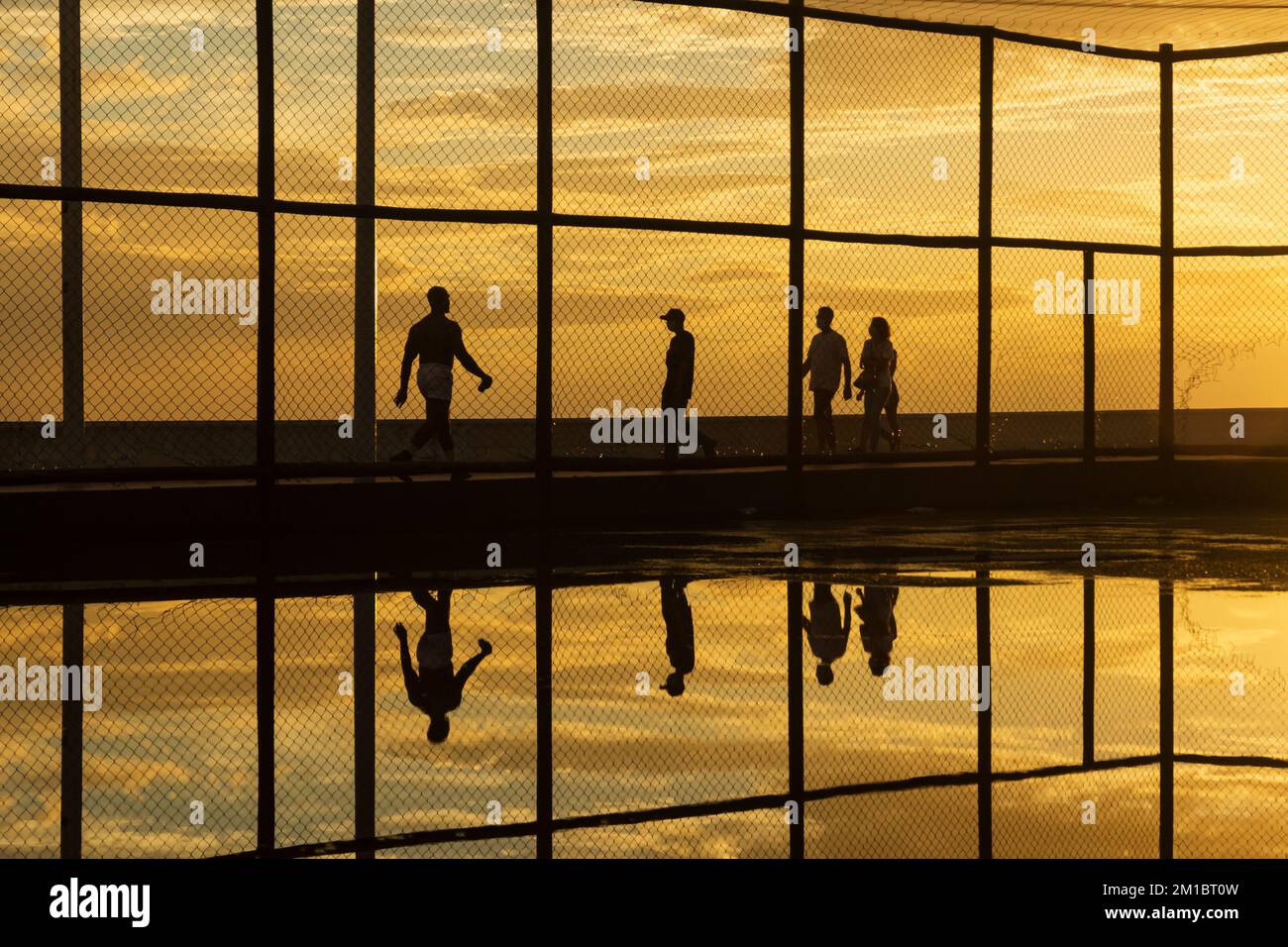 Silhouette of people exercising on the edge of Rio Vermelho beach in ...