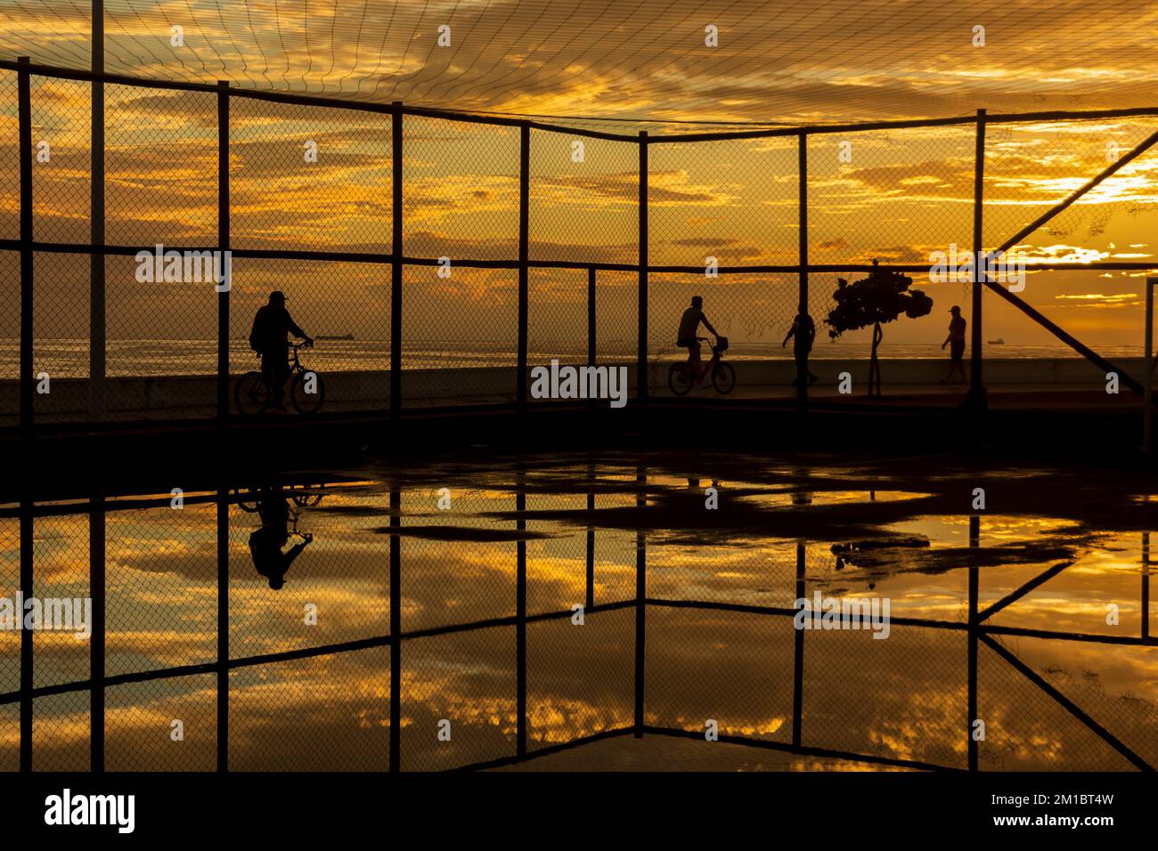 Silhouette of people exercising on the edge of Rio Vermelho beach in ...