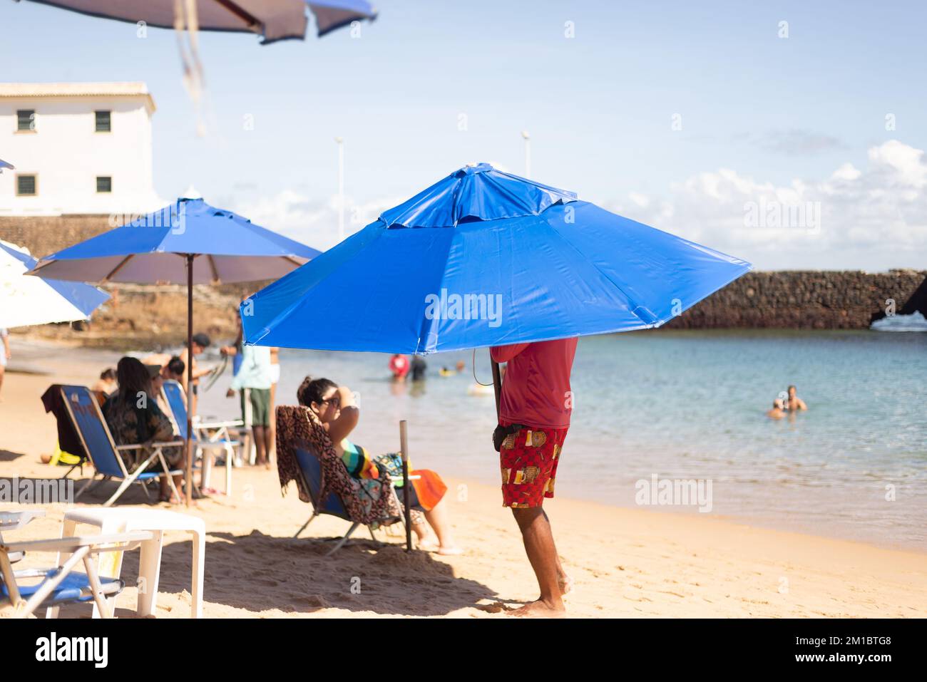 People have fun and swim in the sea at Porto da Barra beach in the city ...