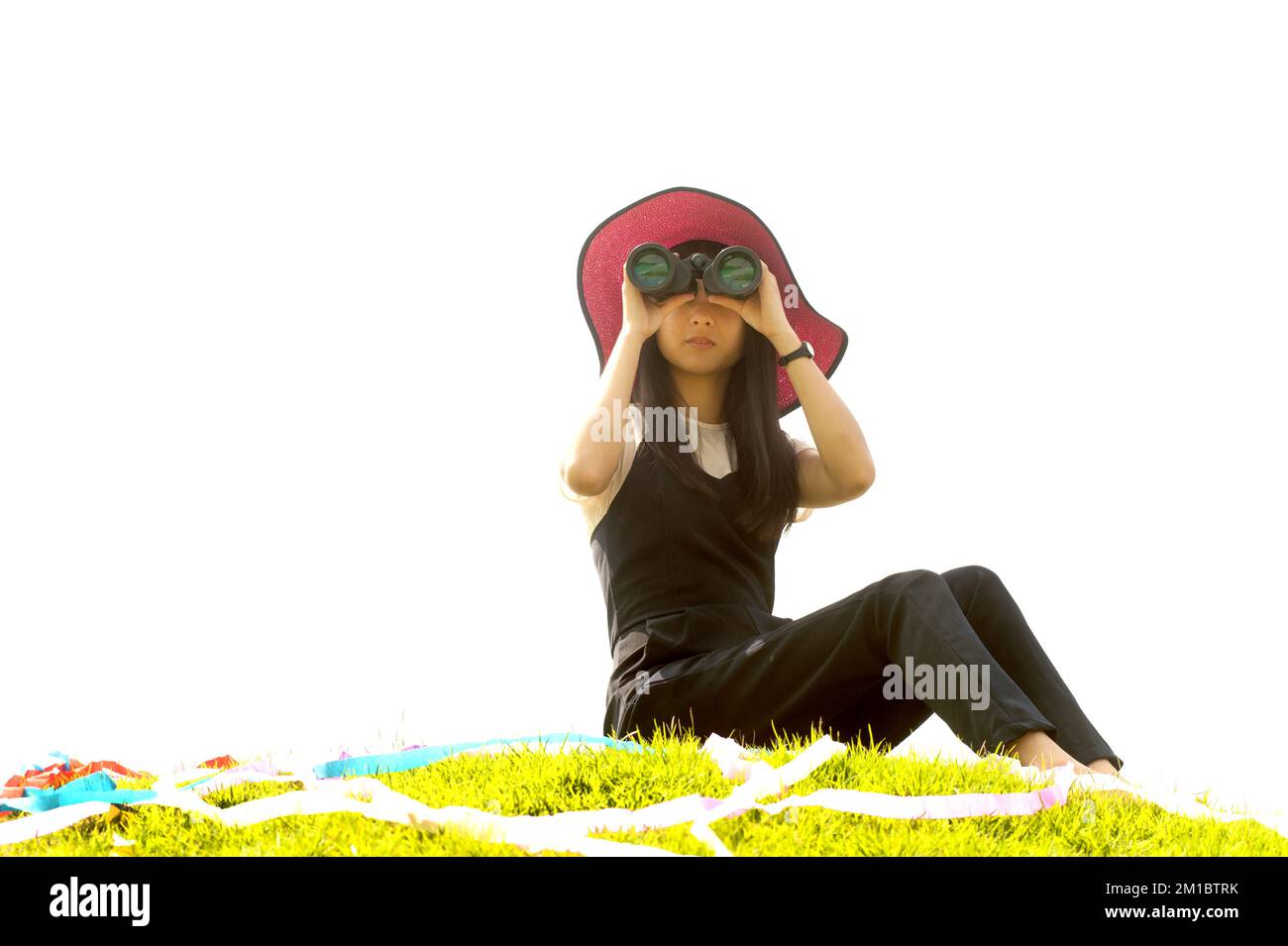 Pretty Asian young woman sit on mound seeking Binoculars Stock Photo ...