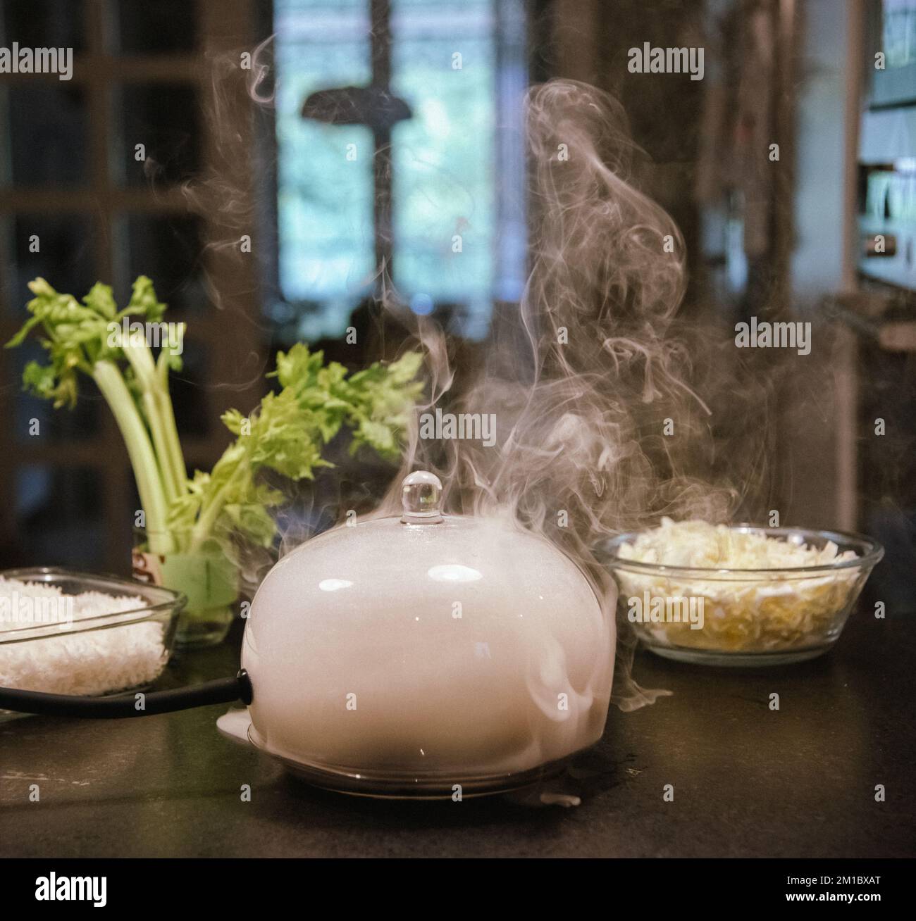 A glass dome cover on a food heating by cold smoke generator with big ...