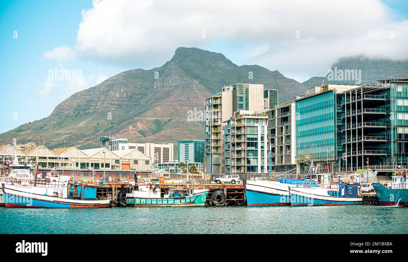 A beautiful view of docked boats on the riverbank with buildings and ...