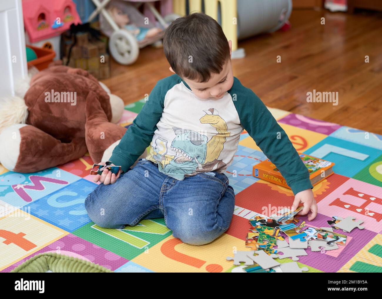cute little boy playing with toys and puzzles in his room Stock Photo ...
