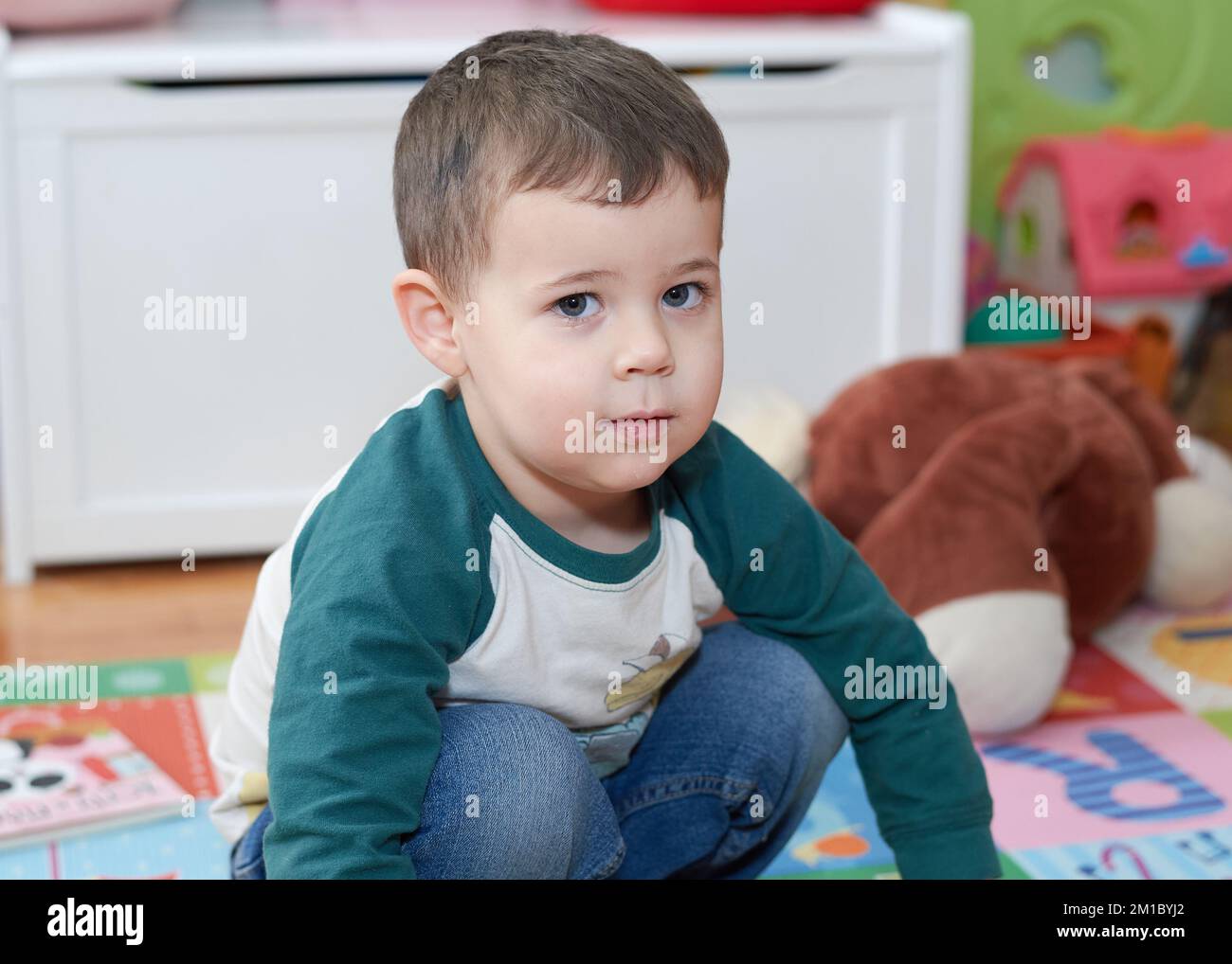 expressive baby boy posing for portraits in his room surrounded by toys ...