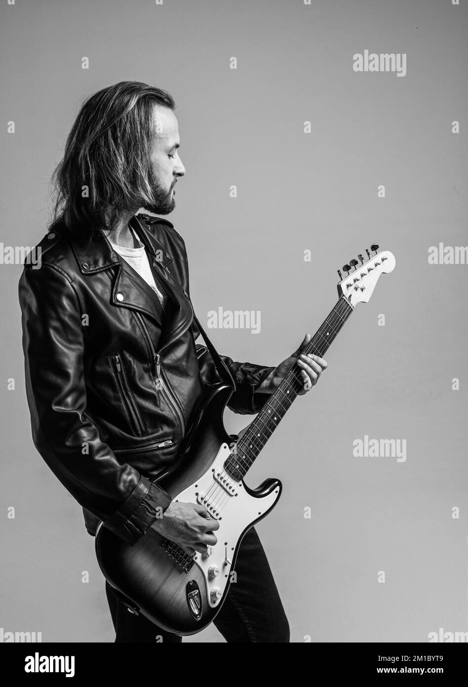 bearded rock musician playing electric guitar in leather jacket, rock ...